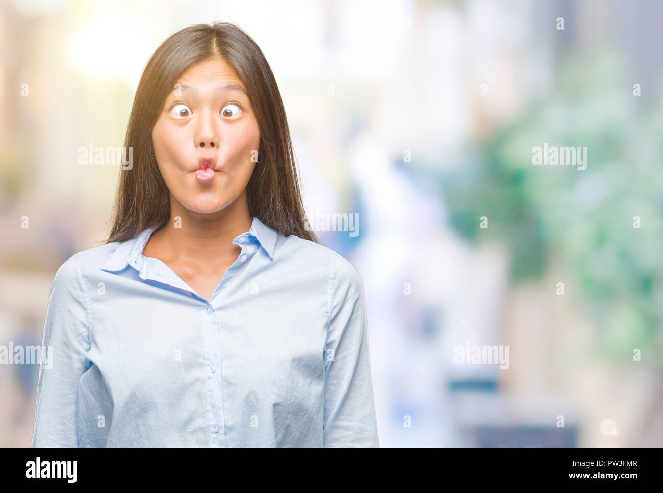 Young asian business woman over isolated background making fish face ...