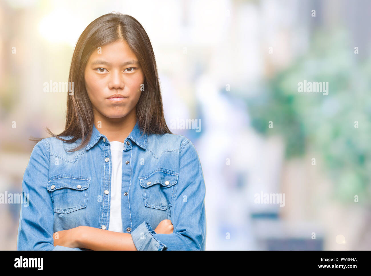 Young asian woman over isolated background skeptic and nervous ...