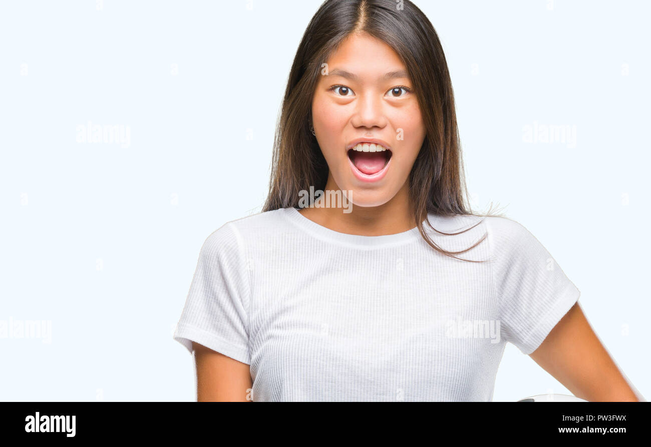 Young asian woman holding football soccer ball over isolated background ...