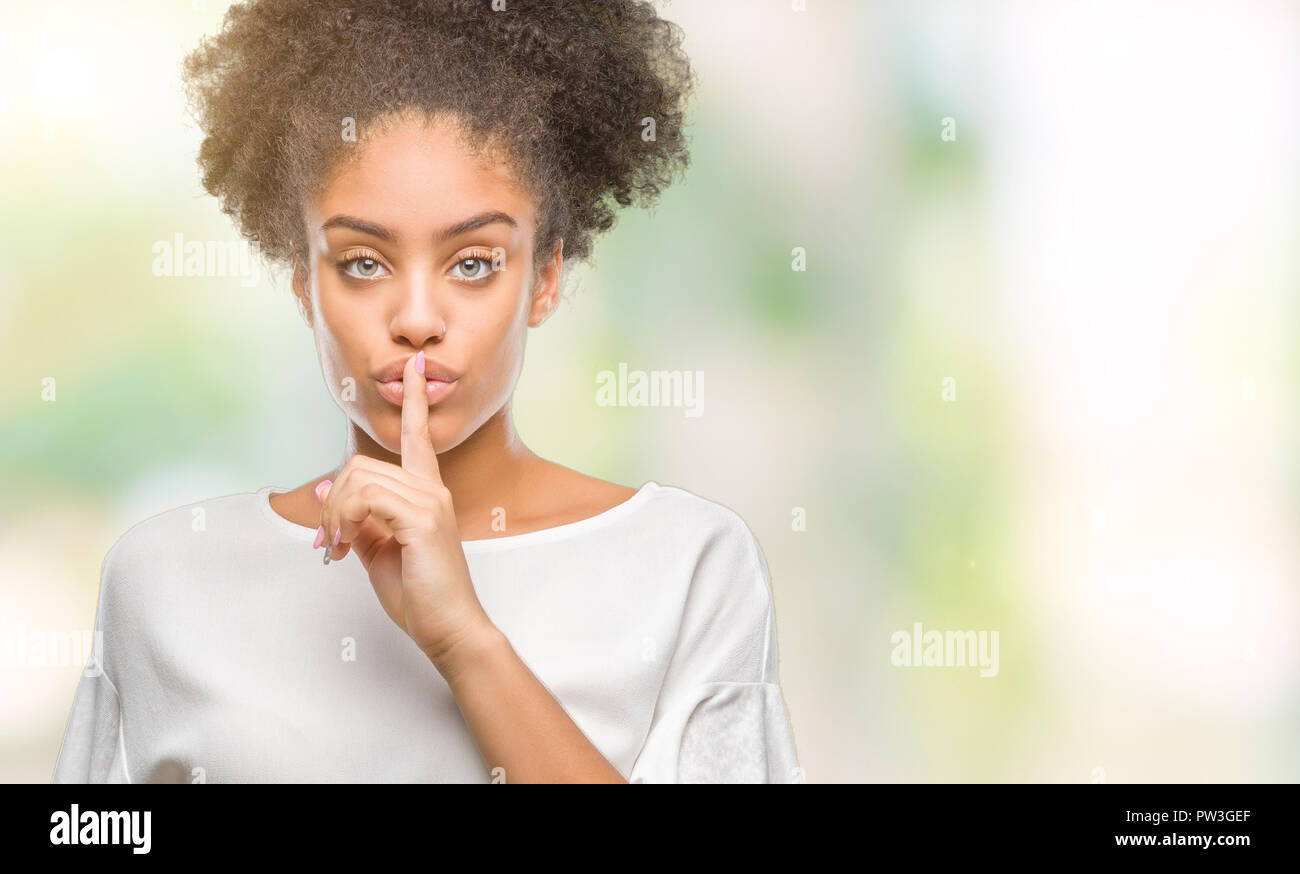 Young afro american woman over isolated background asking to be quiet ...