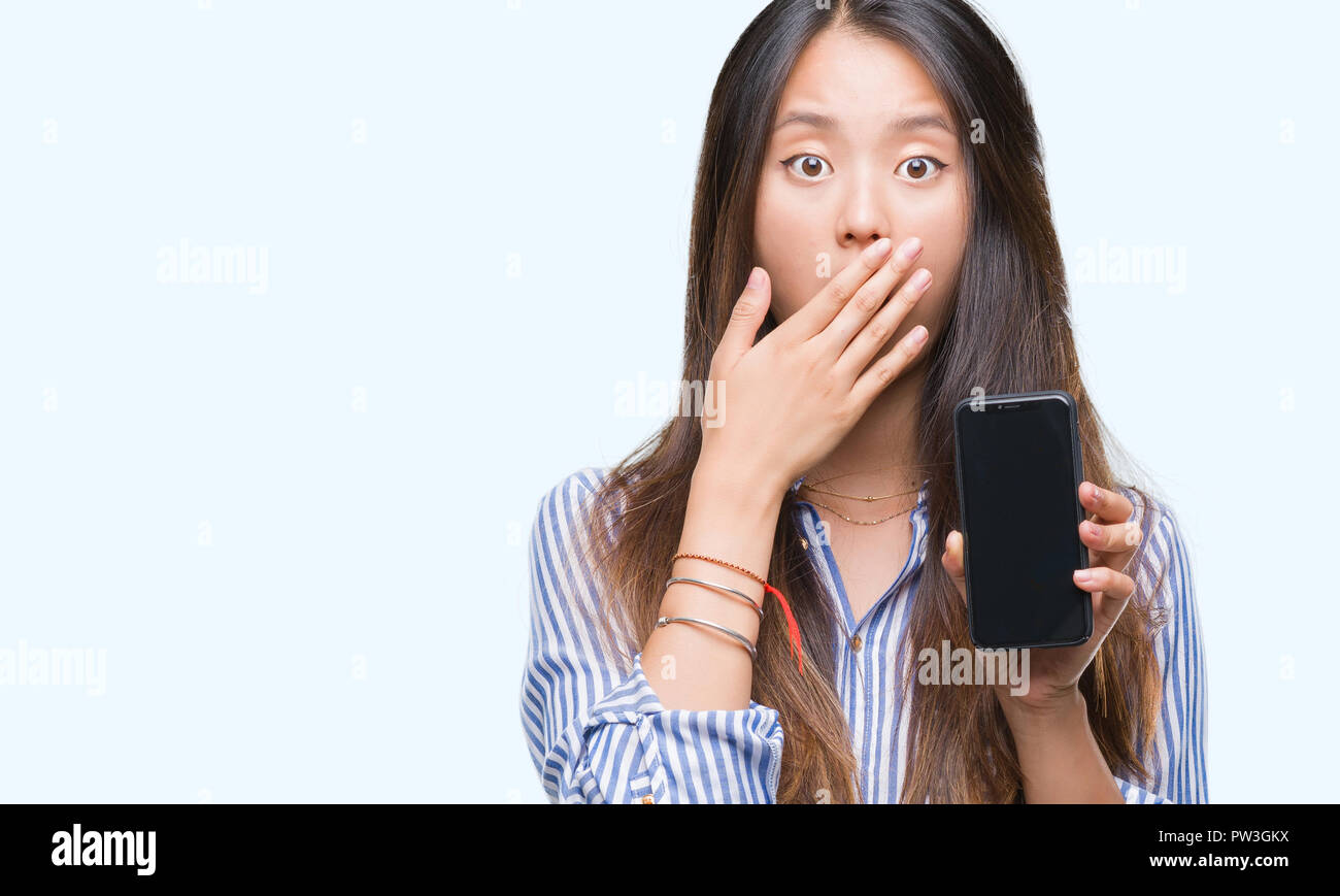 Young asian woman showing blank screen of smartphone over isolated ...