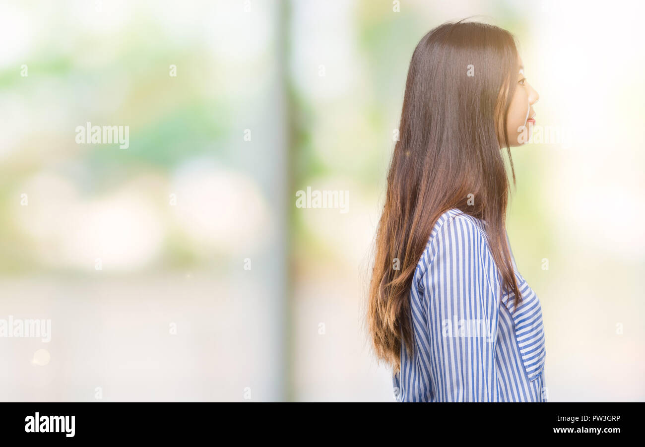 Young asian woman over isolated background looking to side, relax ...