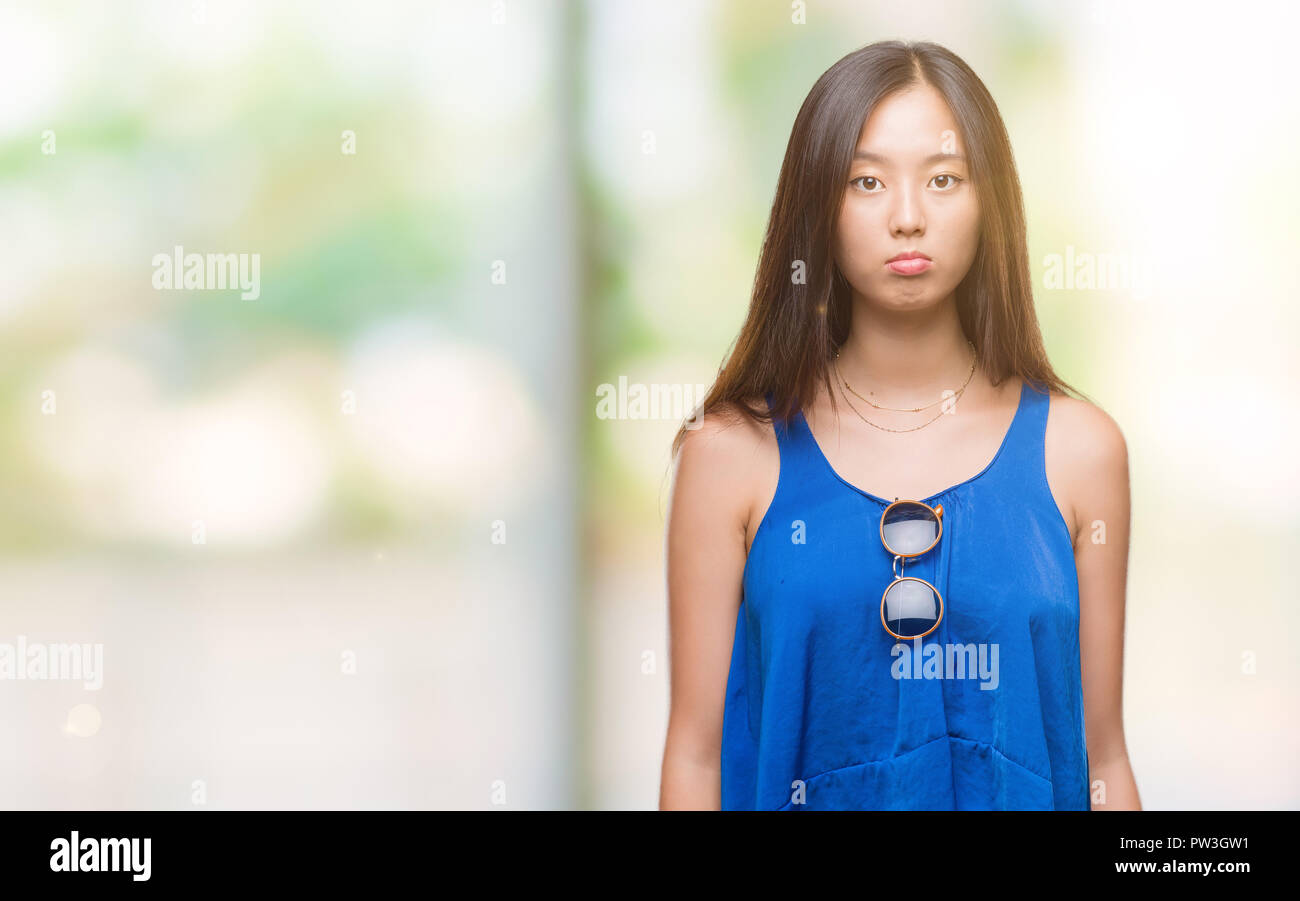 Young asian woman over isolated background depressed and worry for ...