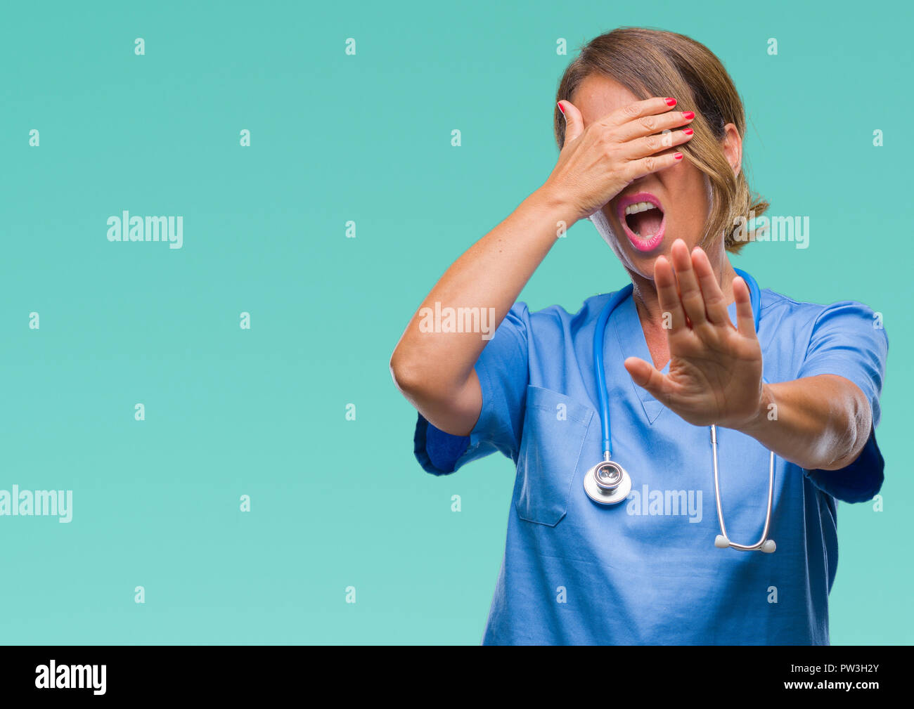 Middle age senior nurse doctor woman over isolated background covering ...