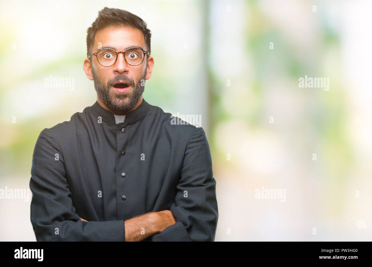 Adult hispanic catholic priest man over isolated background afraid and ...