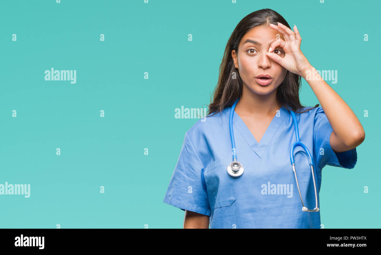 Young arab doctor surgeon woman over isolated background doing ok ...