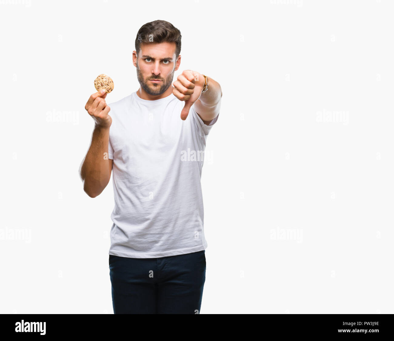 Young handsome man eating chocolate chips cookie over isolated ...