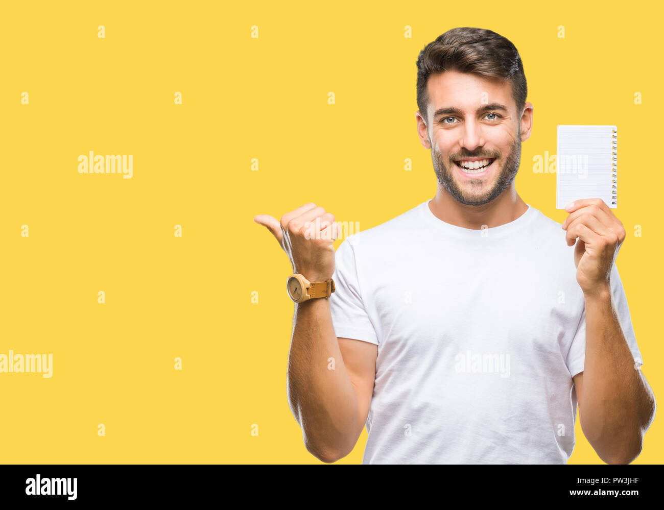 Young handsome man holding notebook over isolated background pointing ...