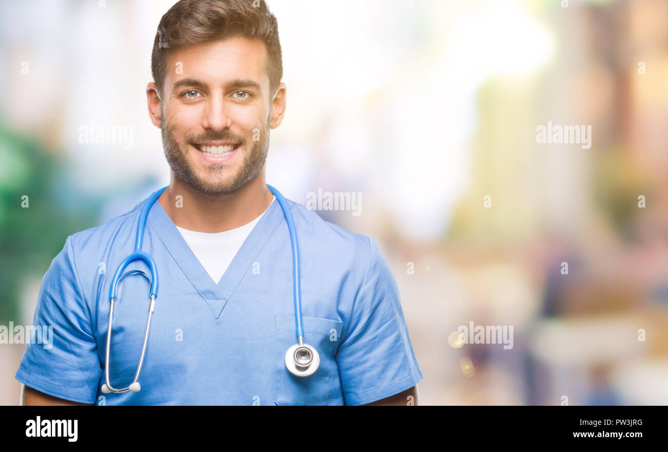 Young handsome doctor nurse man over isolated background with a happy ...