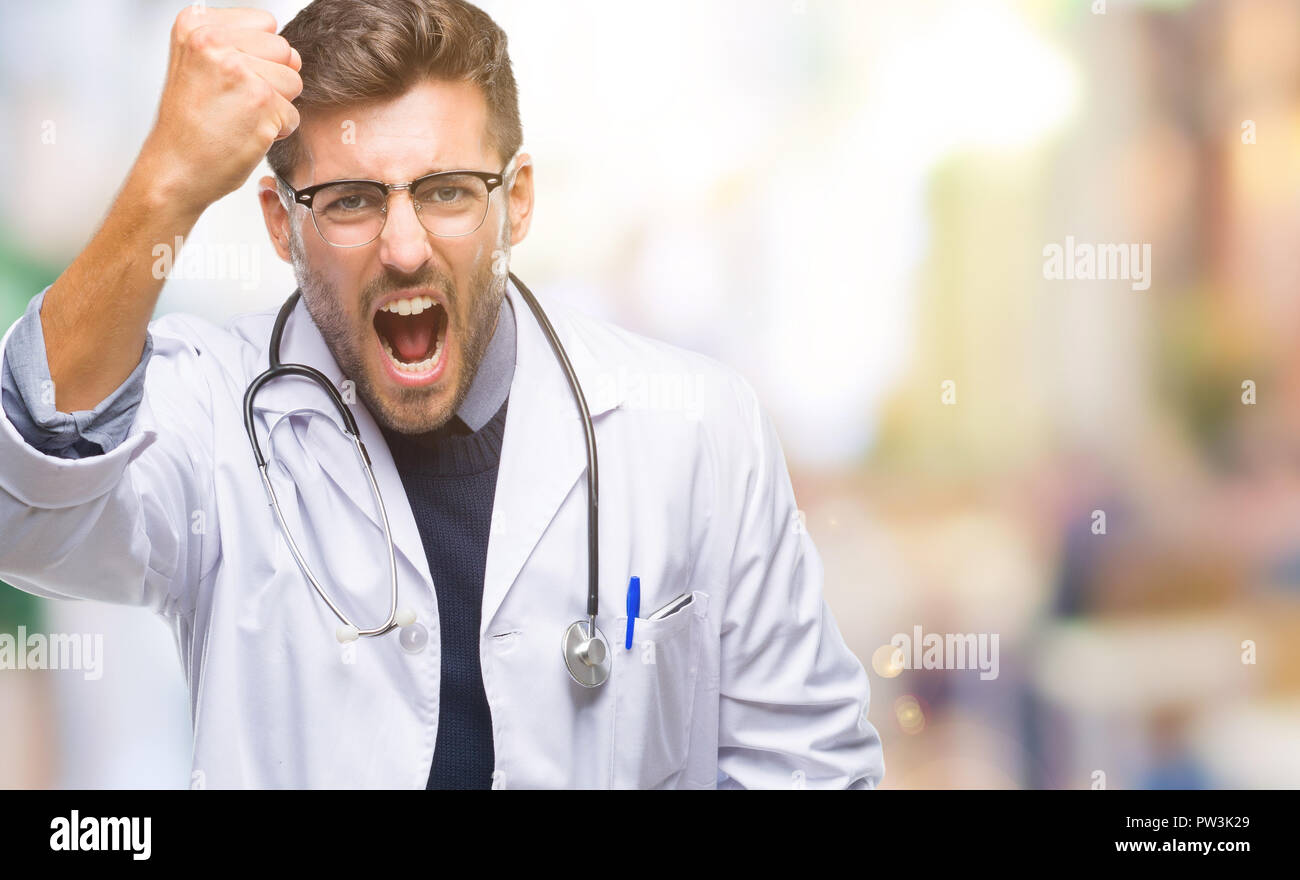 Young handsome doctor man over isolated background angry and mad ...