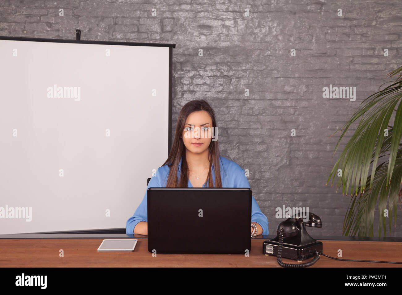 business woman sitting behind the desk Stock Photo - Alamy