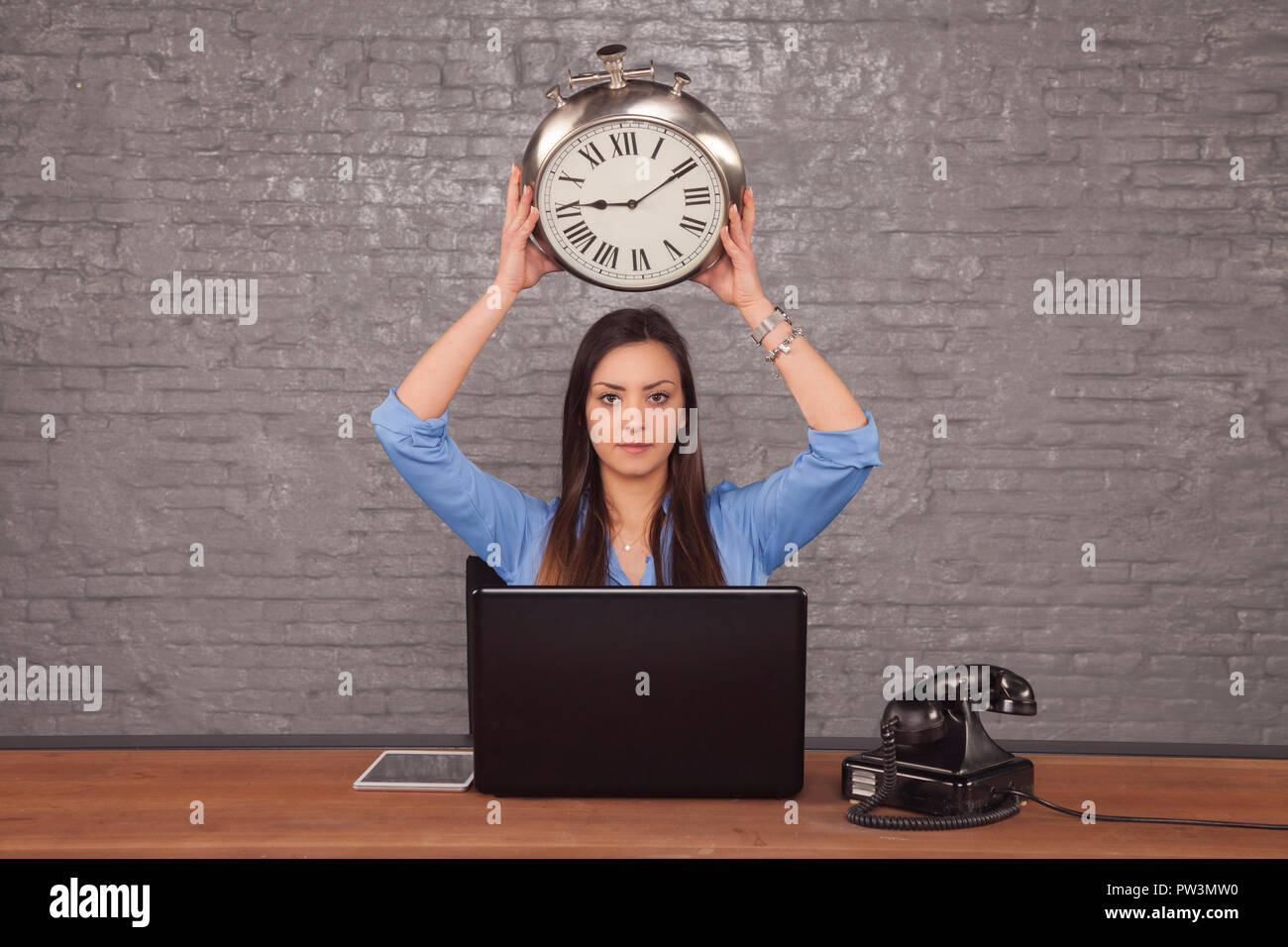 young business woman holding a clock over her head, concept of being on ...