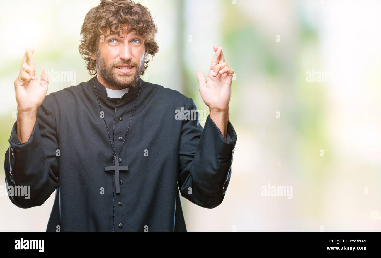 Handsome hispanic catholic priest man over isolated background smiling ...