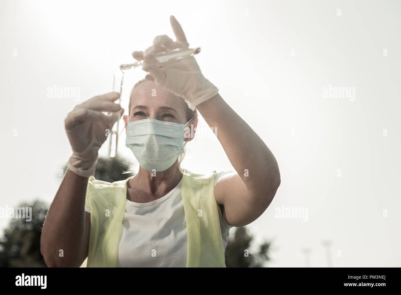 Experienced inspector holding test tubes checking water contamination ...