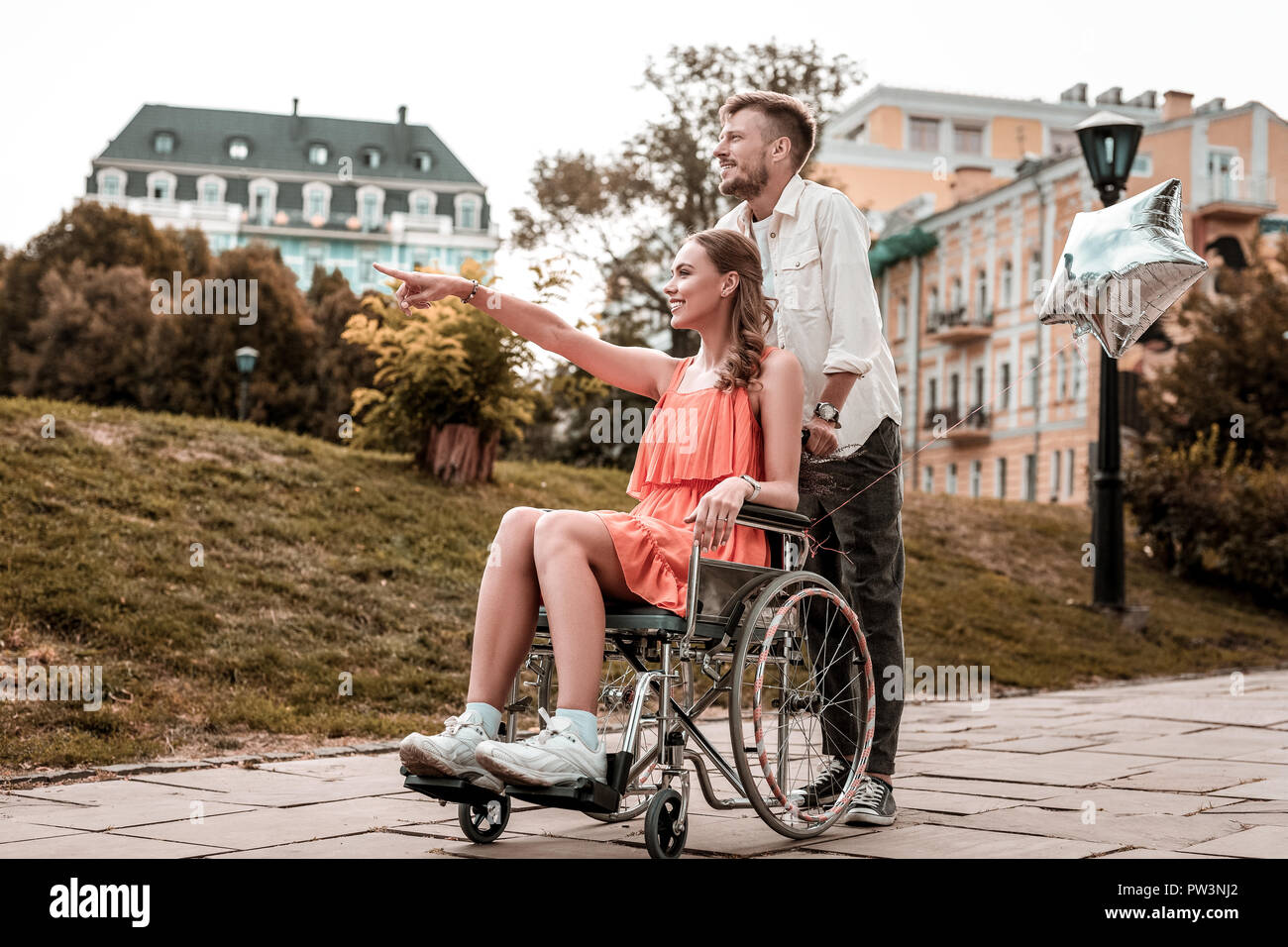 Happy girl pointing to the distance and her boyfriend looking there ...