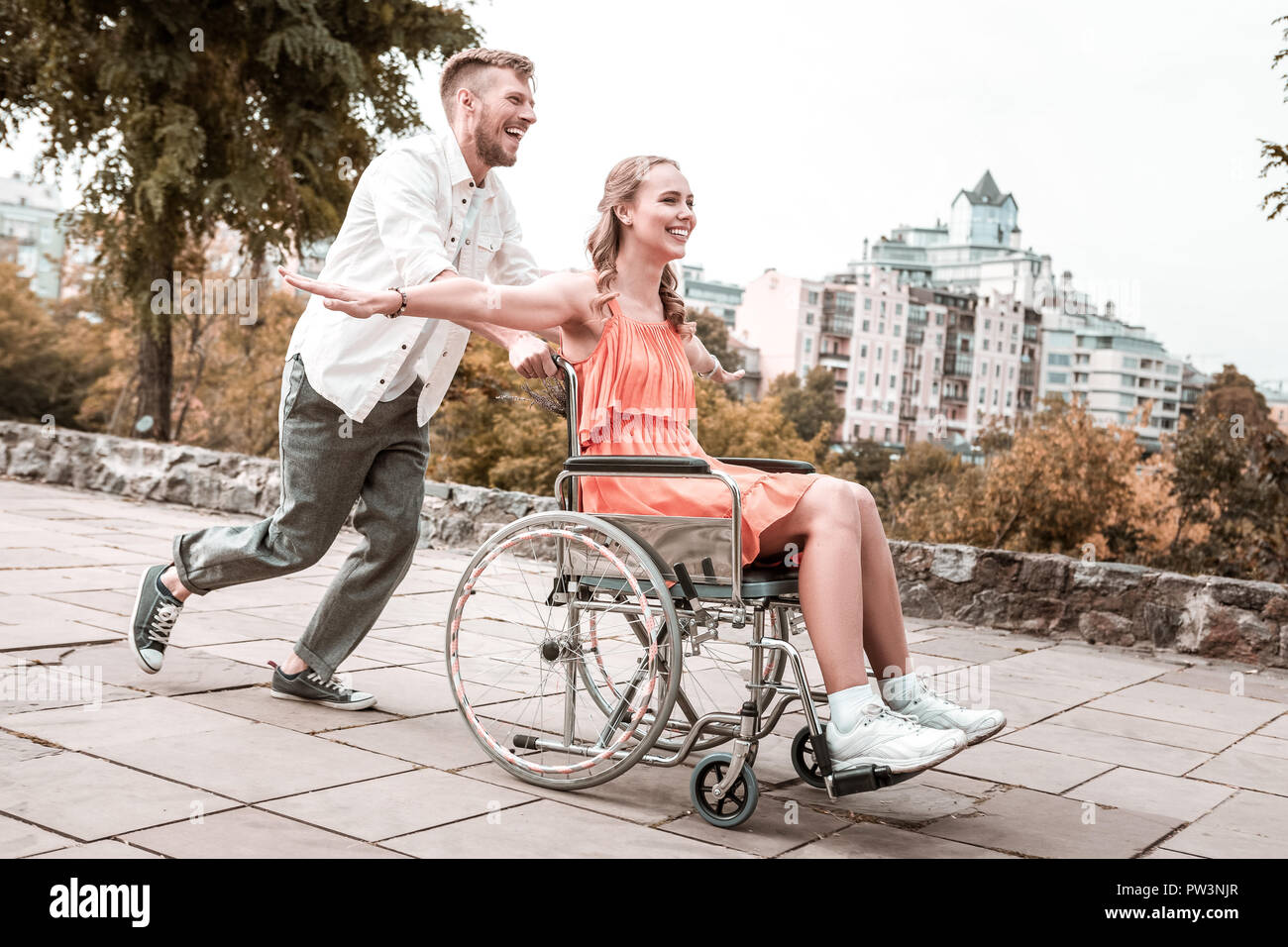 Emotional man pushing the wheelchair and his disabled girlfriend ...
