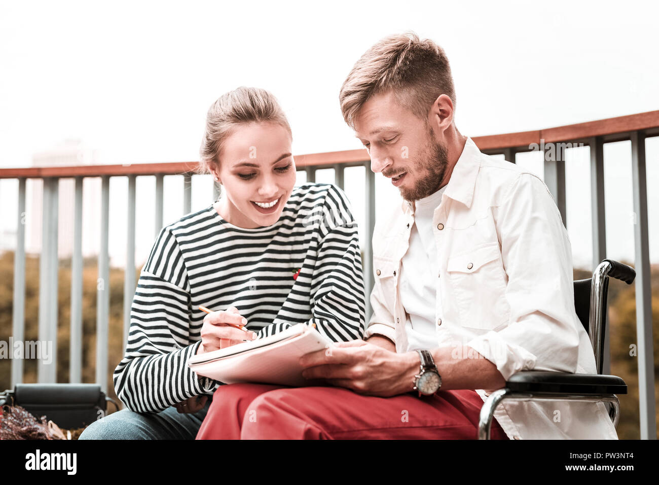Two people smiling while making notes together Stock Photo - Alamy