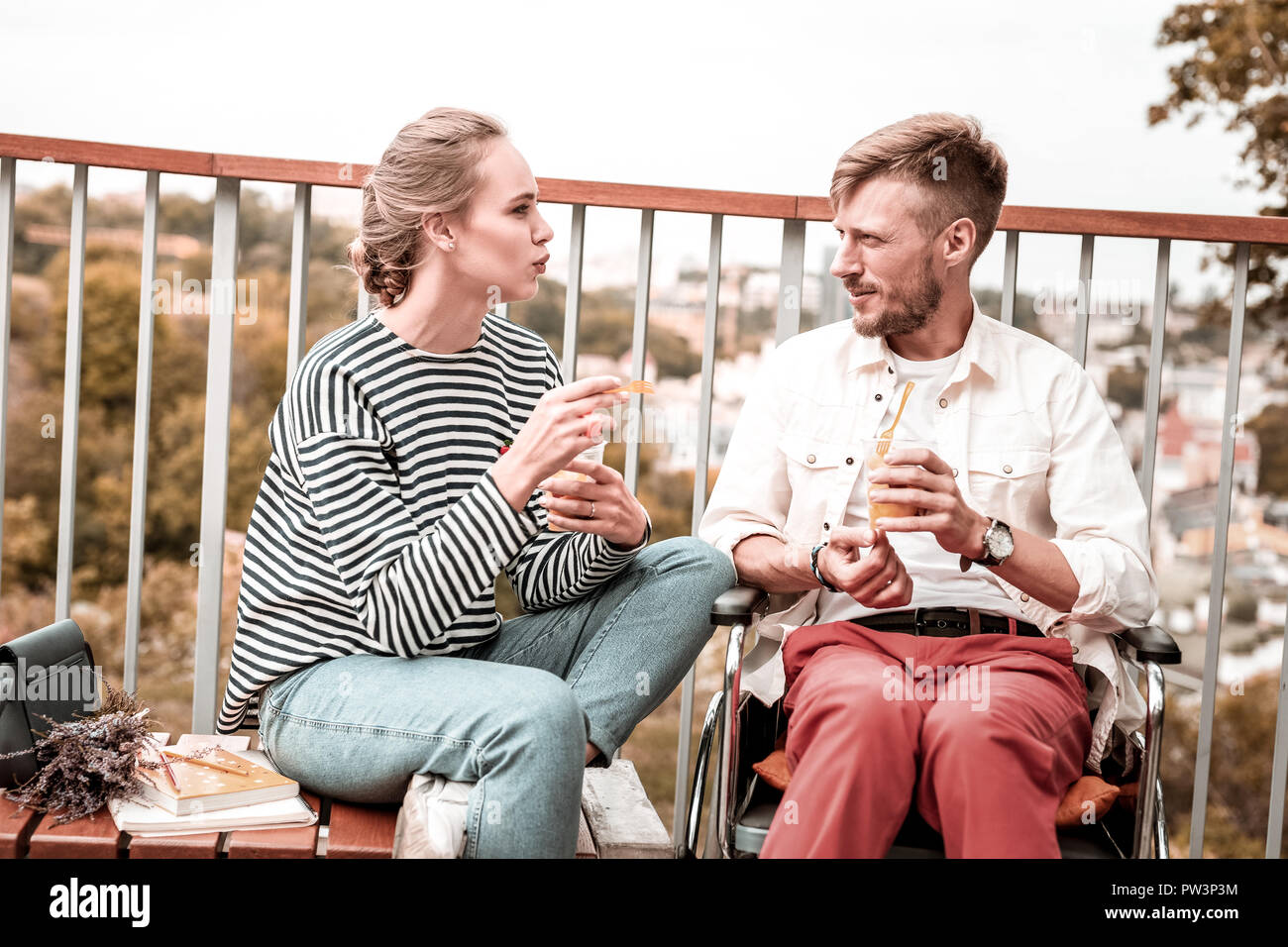Two friends eating fruit in the park and talking Stock Photo - Alamy