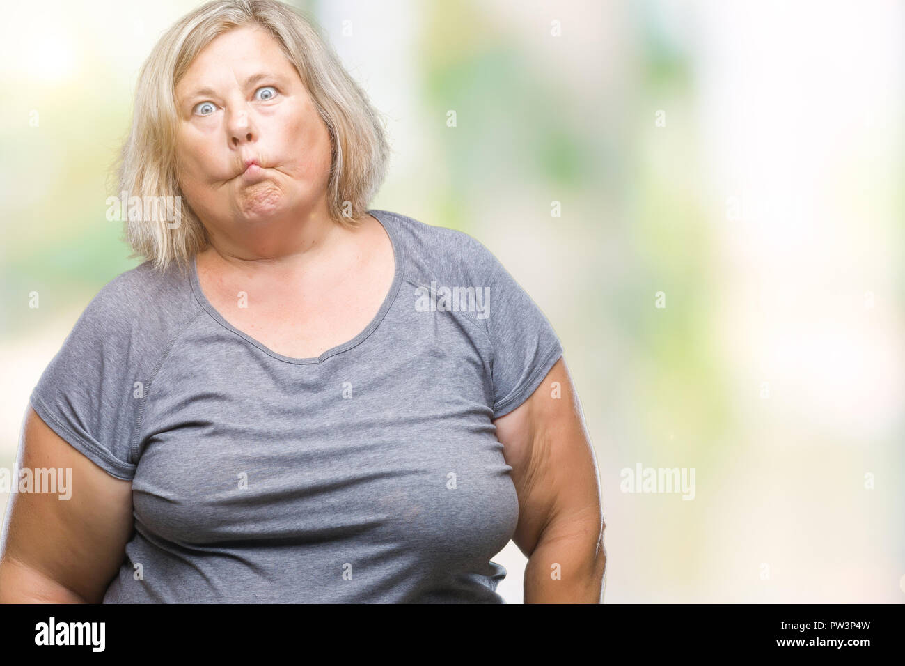 Senior plus size caucasian woman over isolated background making fish ...