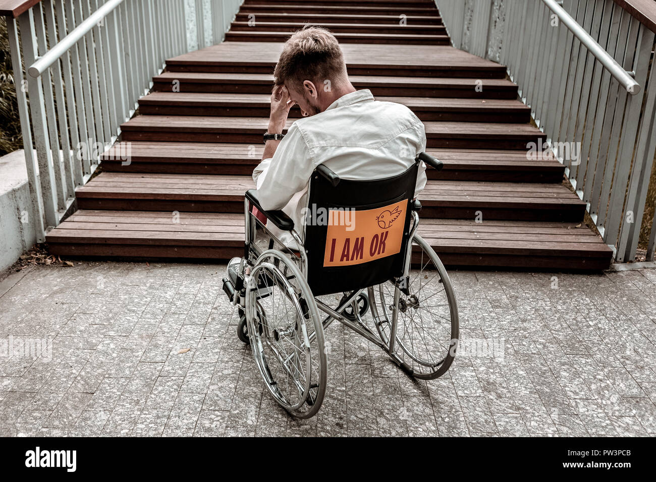 Disabled man facing big barrier and looking hopeless Stock Photo - Alamy