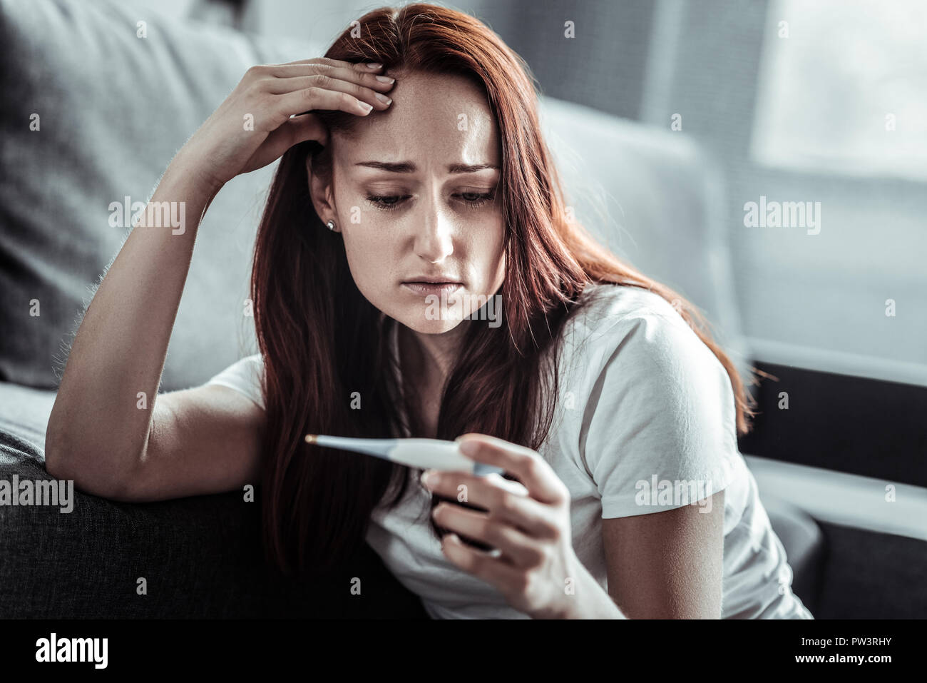 Portrait of thoughtful female that checking temperature Stock Photo - Alamy