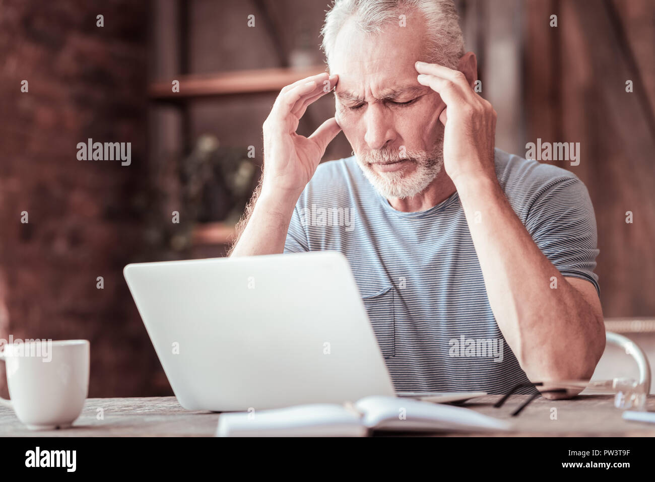 Close up of tired man touching his head Stock Photo - Alamy
