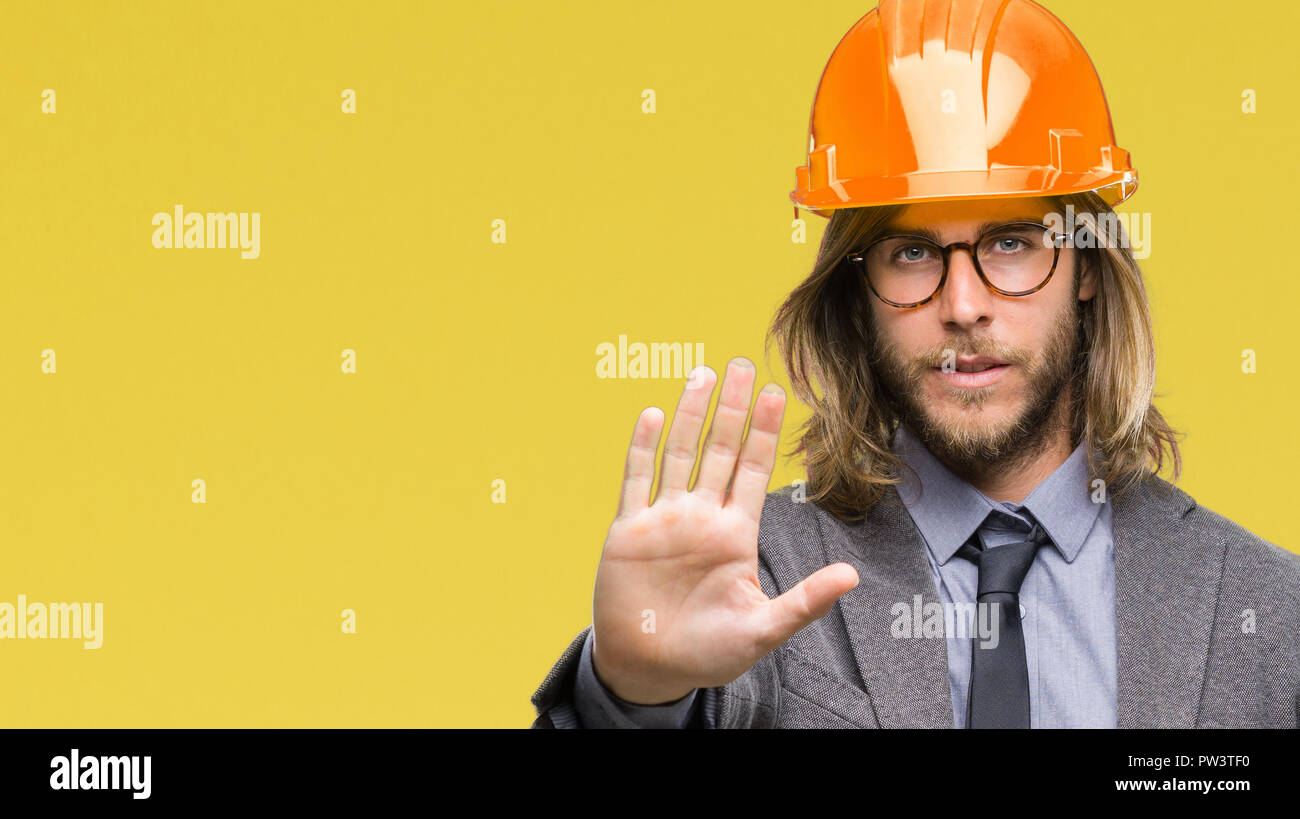 Young handsome architec man with long hair wearing safety helmet over ...