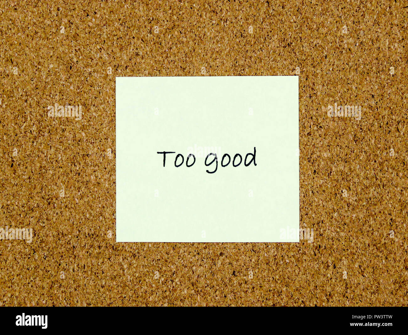 A yellow sticky note with too good written on it on a cork board ...