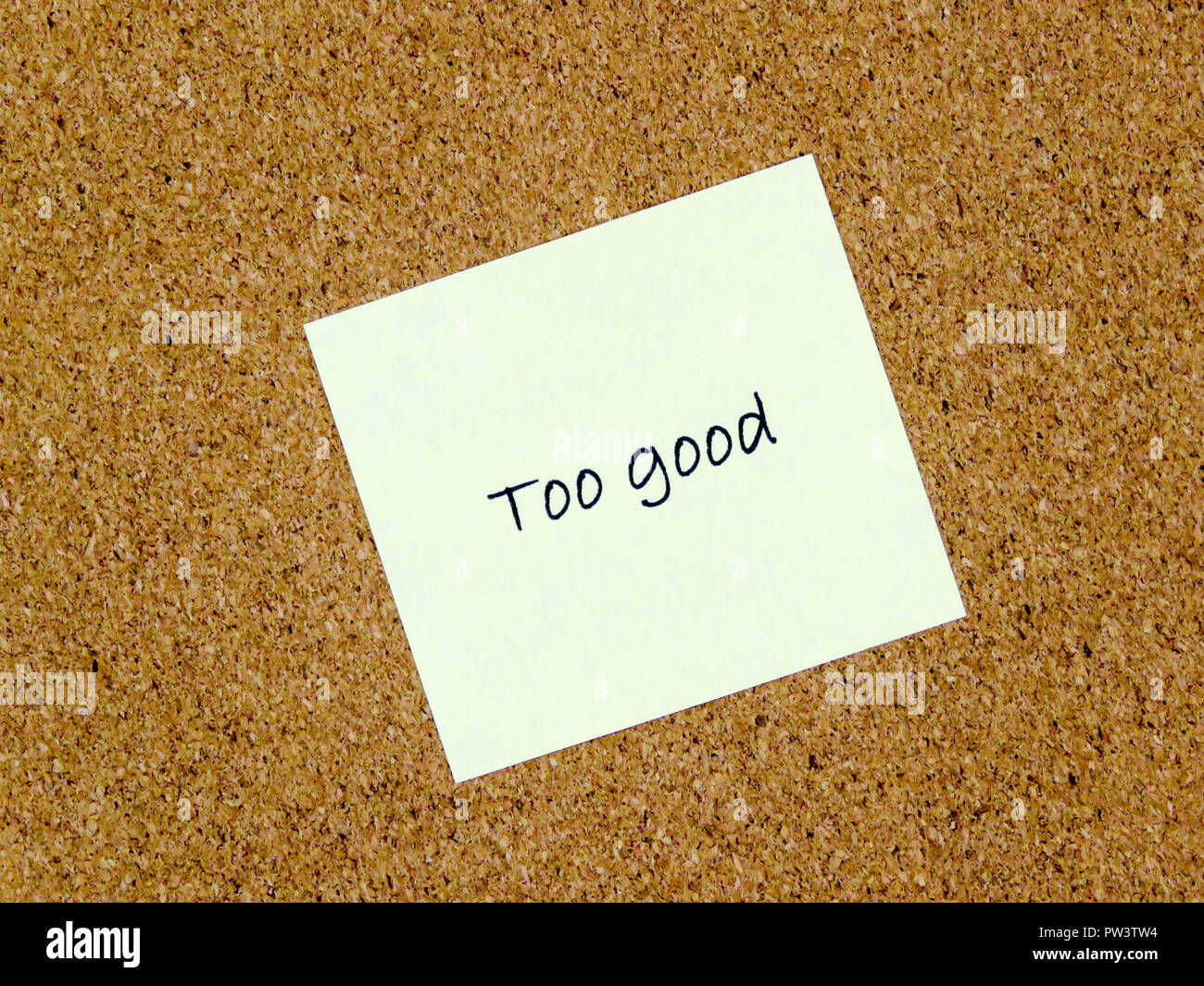A yellow sticky note with too good written on it on a cork board ...
