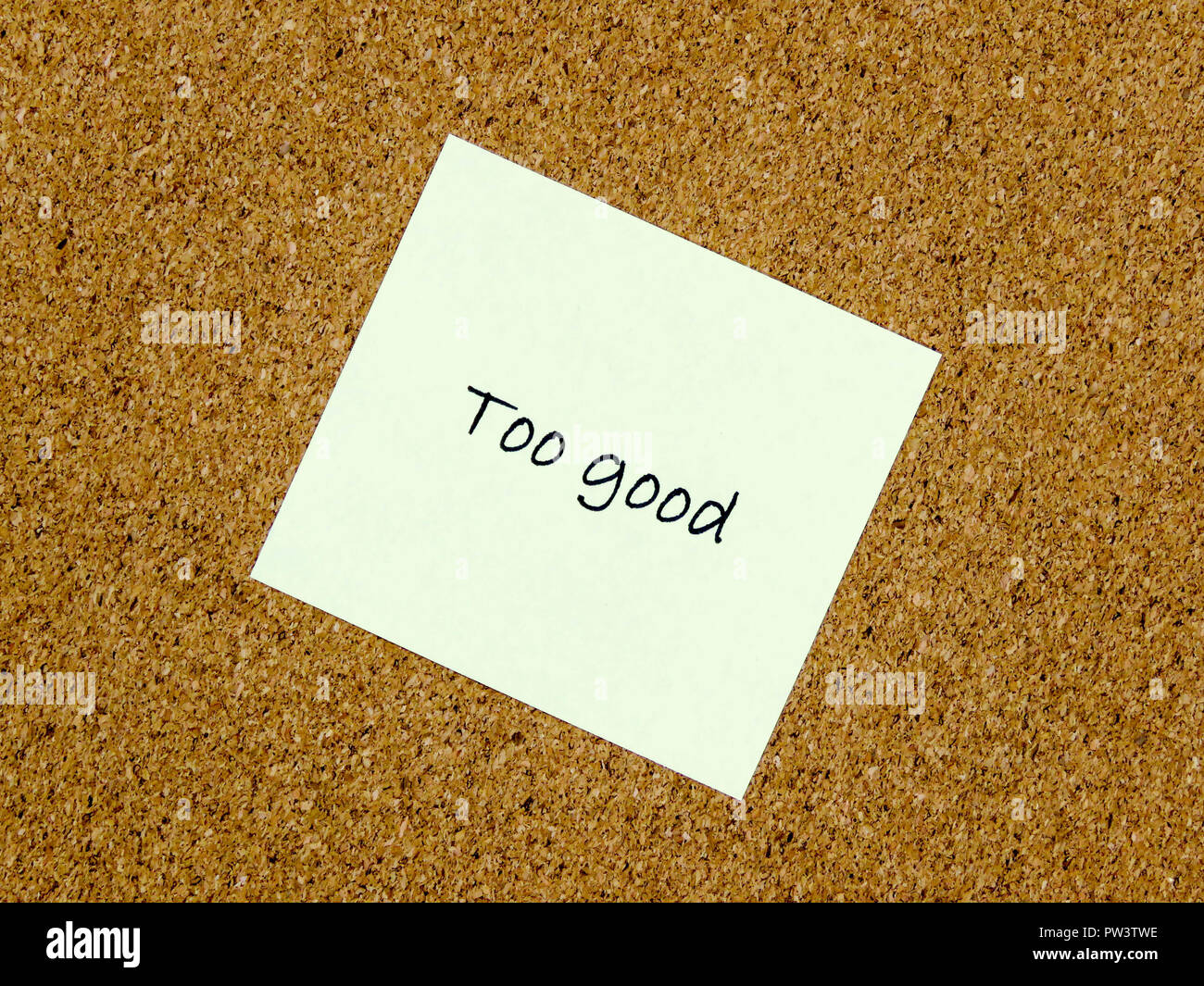 A yellow sticky note with too good written on it on a cork board ...