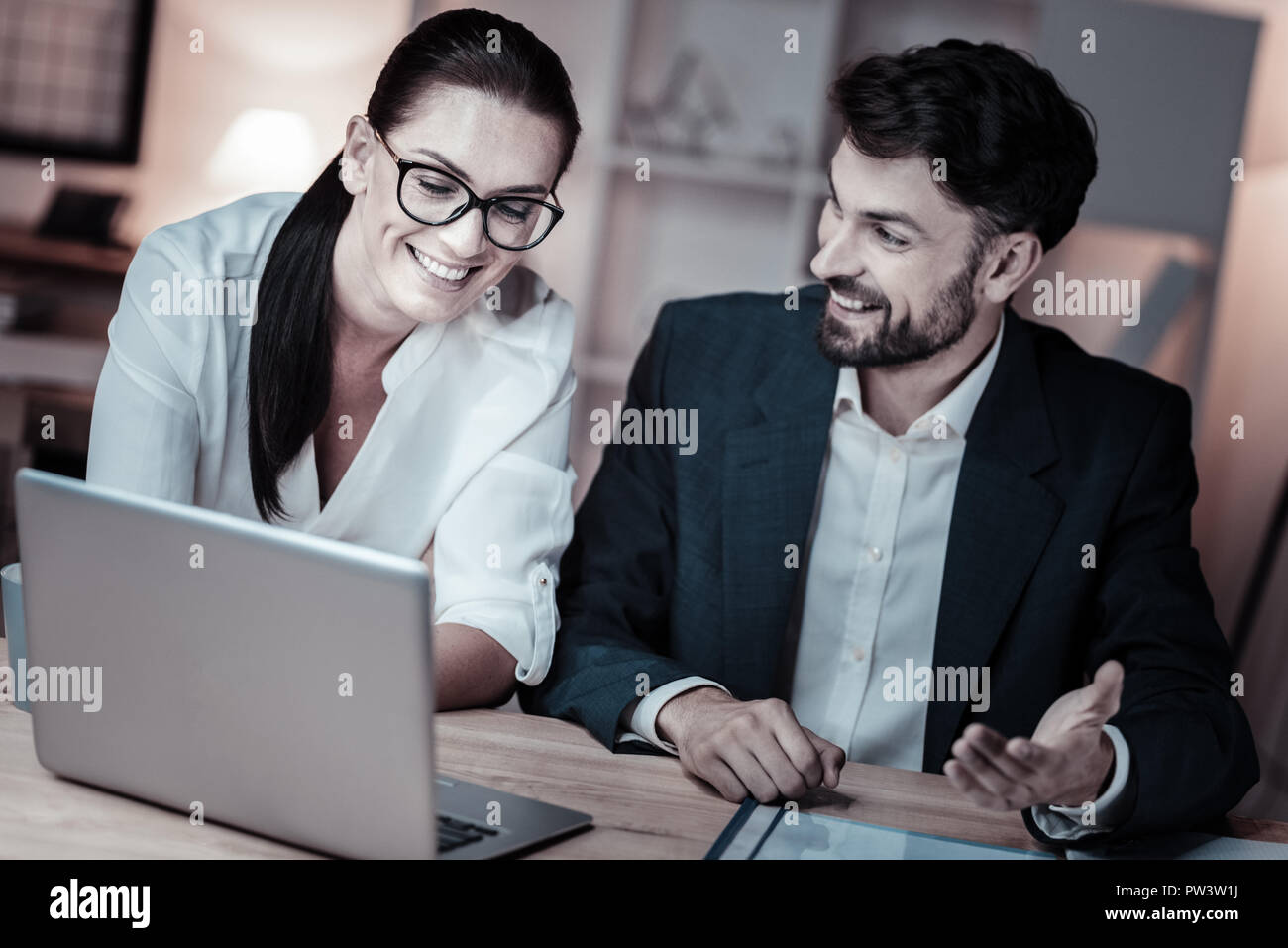 Happy colleagues discussing their project Stock Photo - Alamy