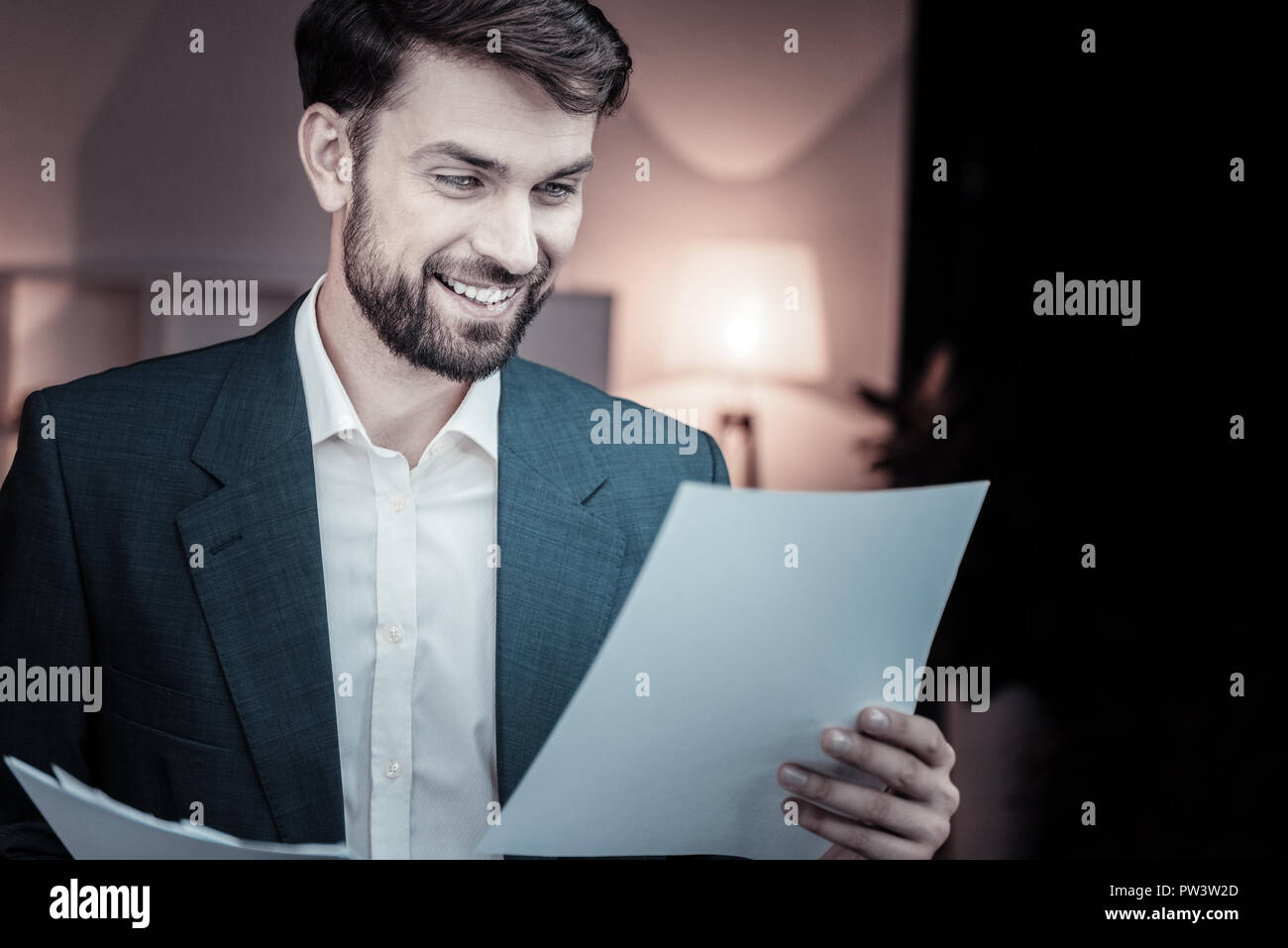 Positive delighted man reading document Stock Photo - Alamy
