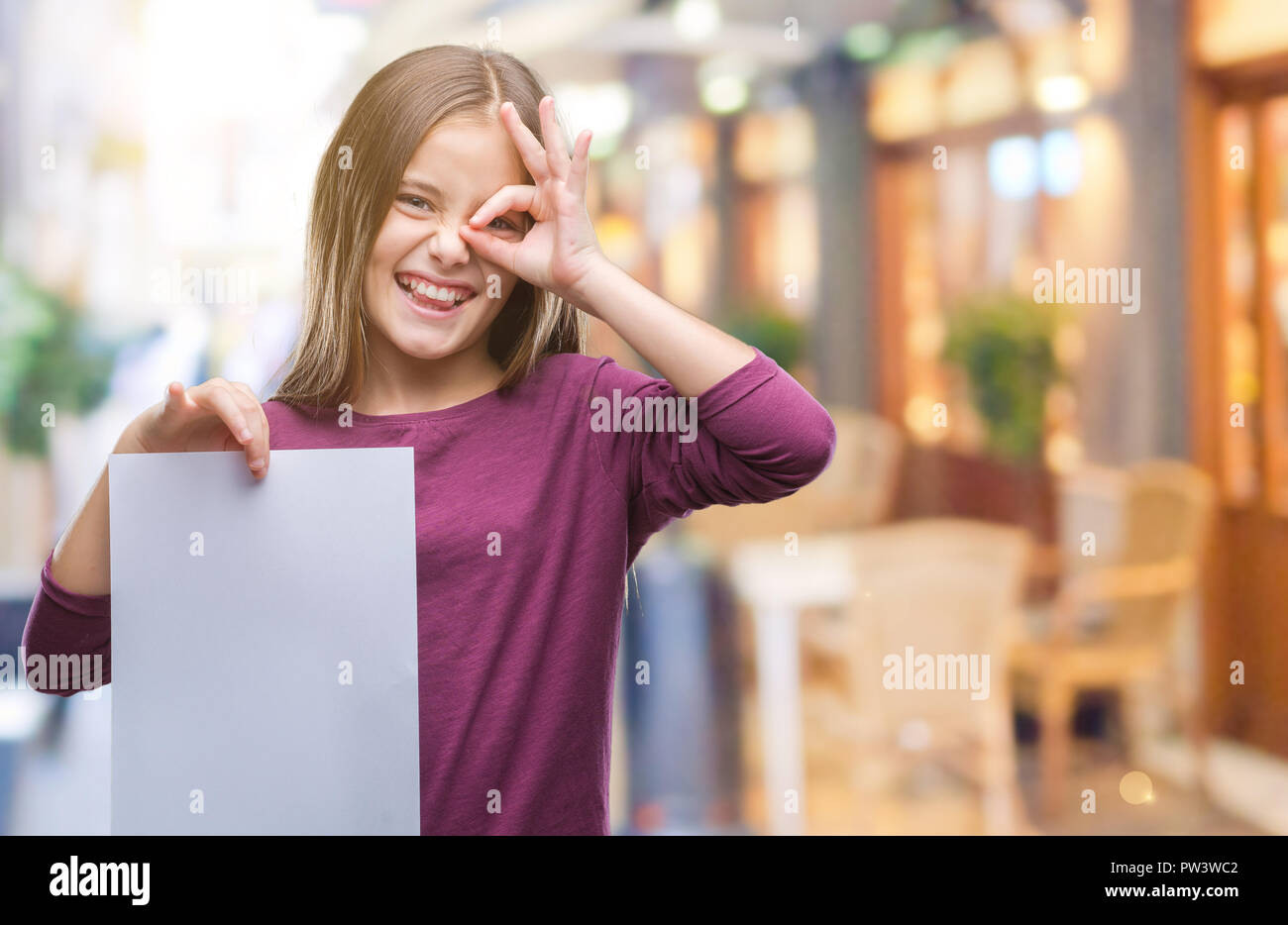 Young beautiful girl holding blank sheet paper over isolated background ...
