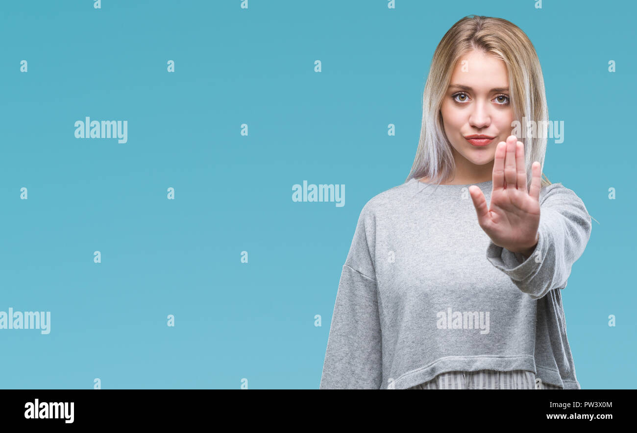 Young blonde woman over isolated background doing stop sing with palm ...