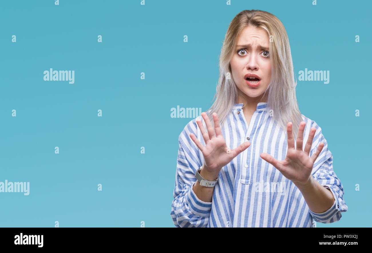 Young blonde woman over isolated background afraid and terrified with ...