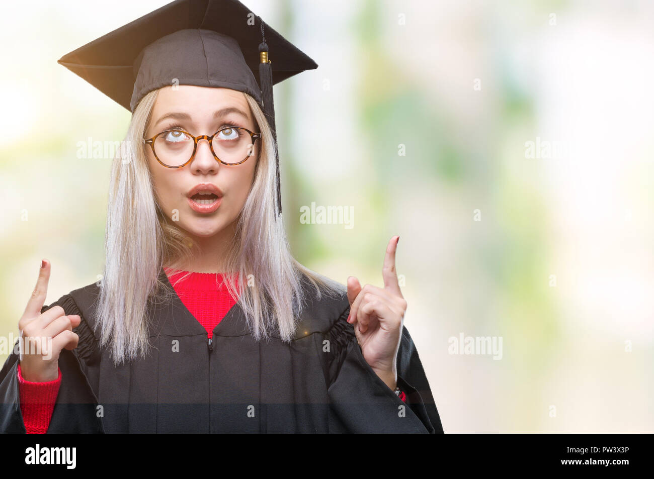 Young blonde woman wearing graduate uniform over isolated background ...