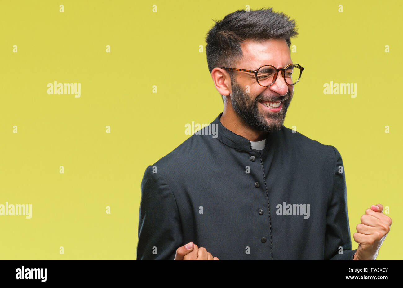 Adult hispanic catholic priest man over isolated background very happy ...