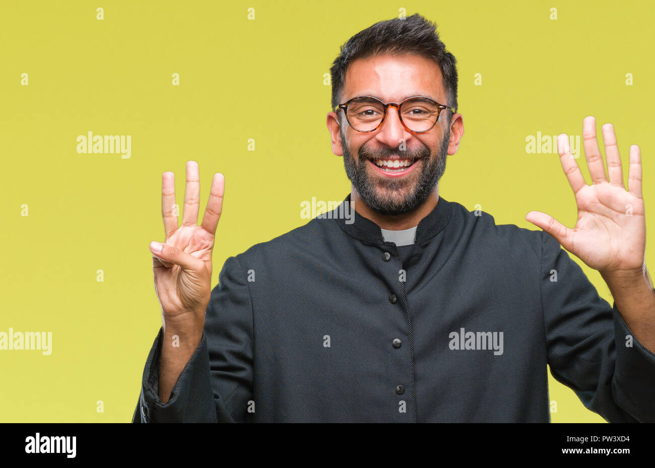 Adult hispanic catholic priest man over isolated background showing and ...