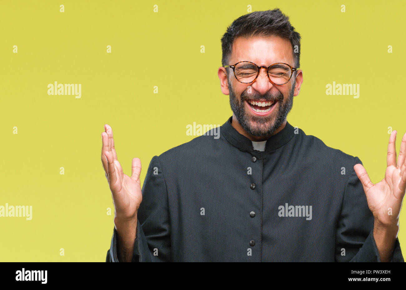 Adult hispanic catholic priest man over isolated background celebrating ...