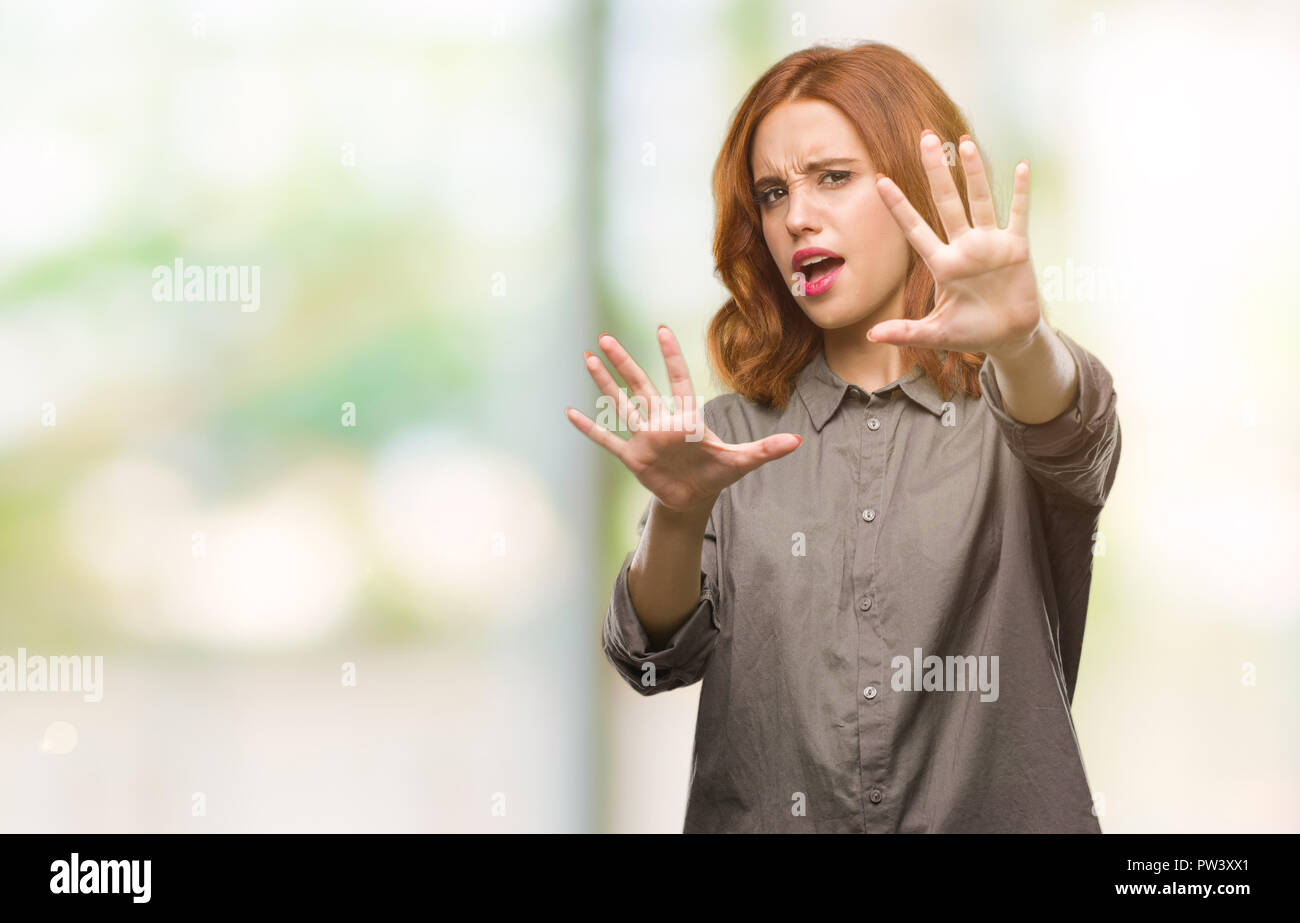 Young beautiful woman over isolated background afraid and terrified ...