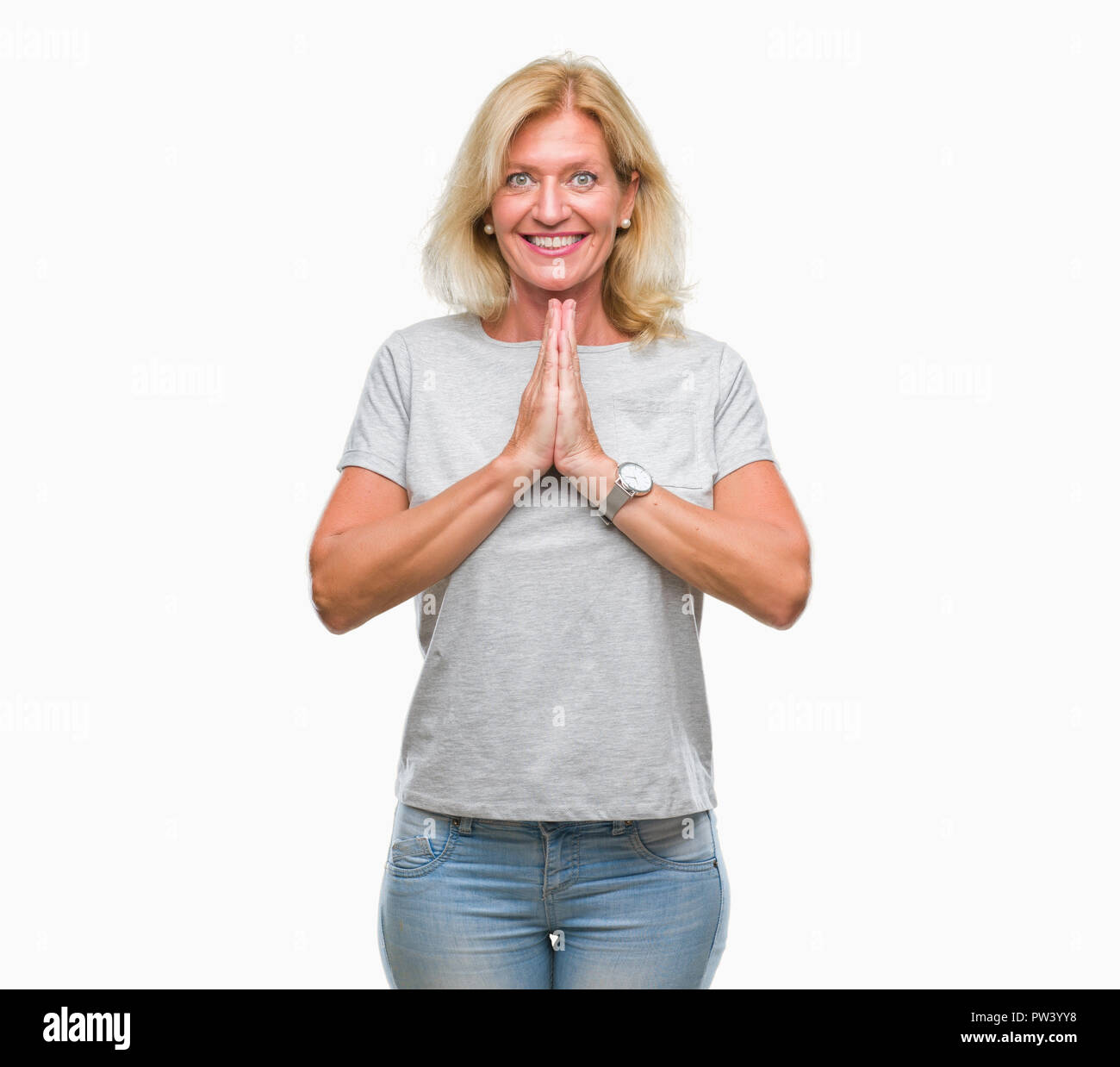Middle age blonde woman over isolated background praying with hands together asking for ...