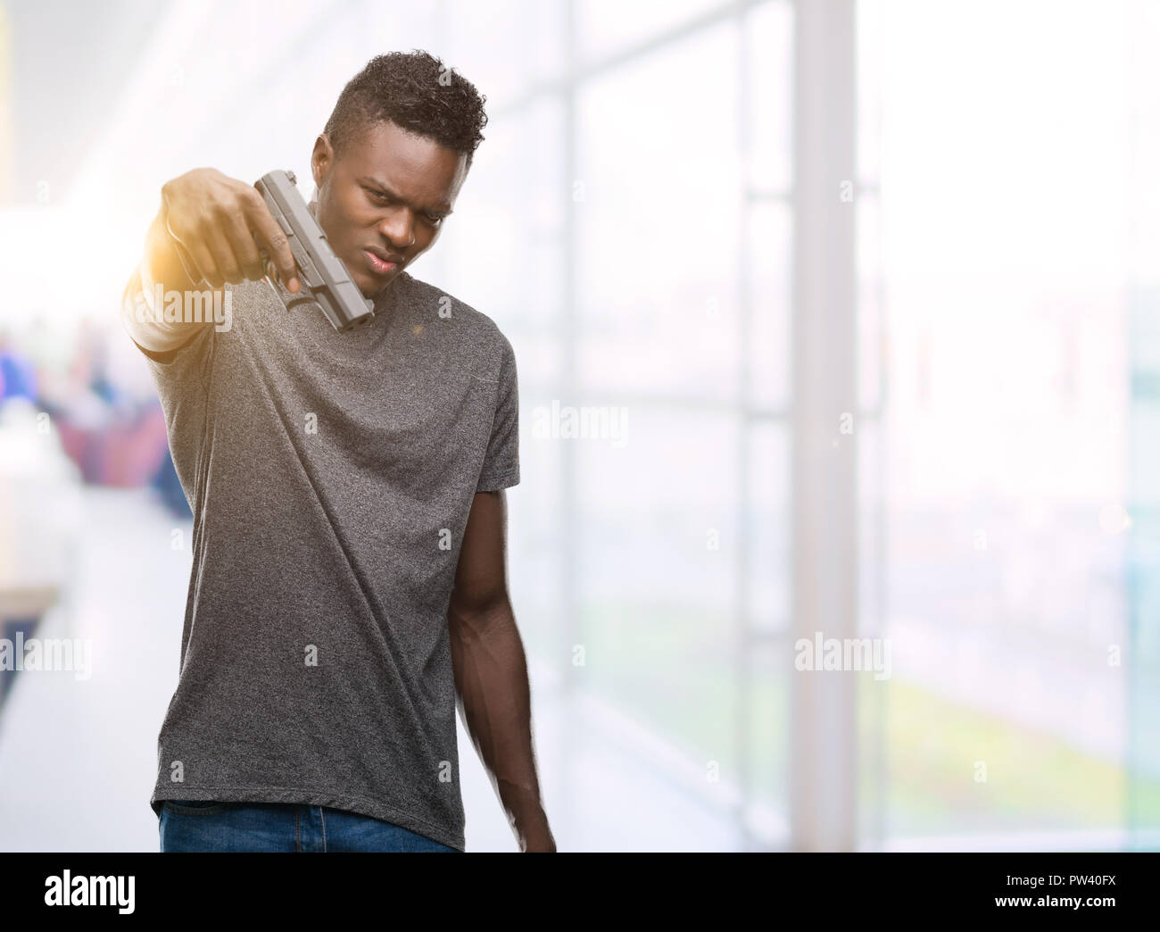 Young african american man holding a gun with a confident expression on ...