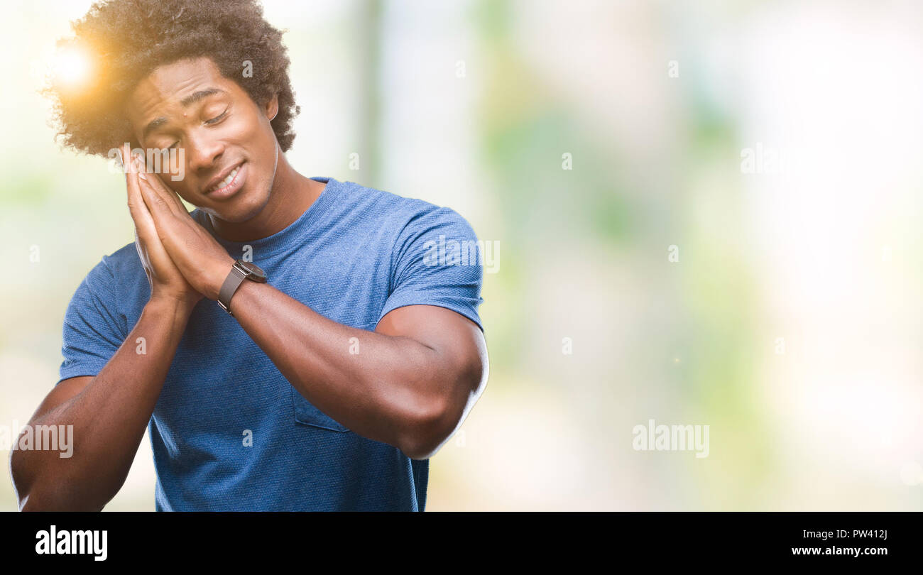 Afro american man over isolated background sleeping tired dreaming and ...