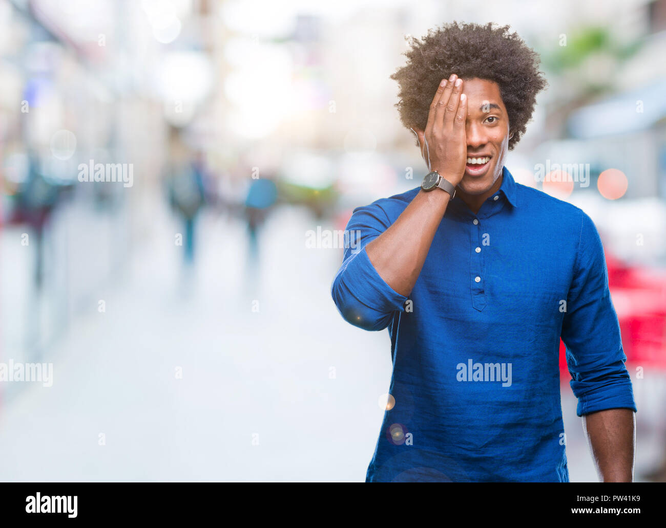 Afro american man over isolated background covering one eye with hand ...