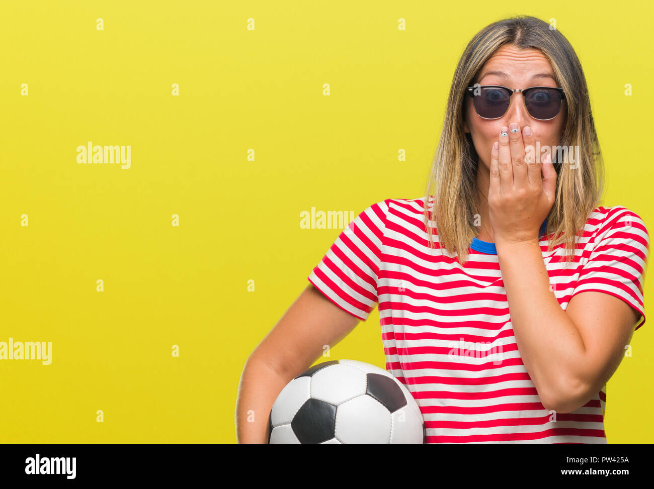 Young beautiful woman holding soccer football ball over isolated ...