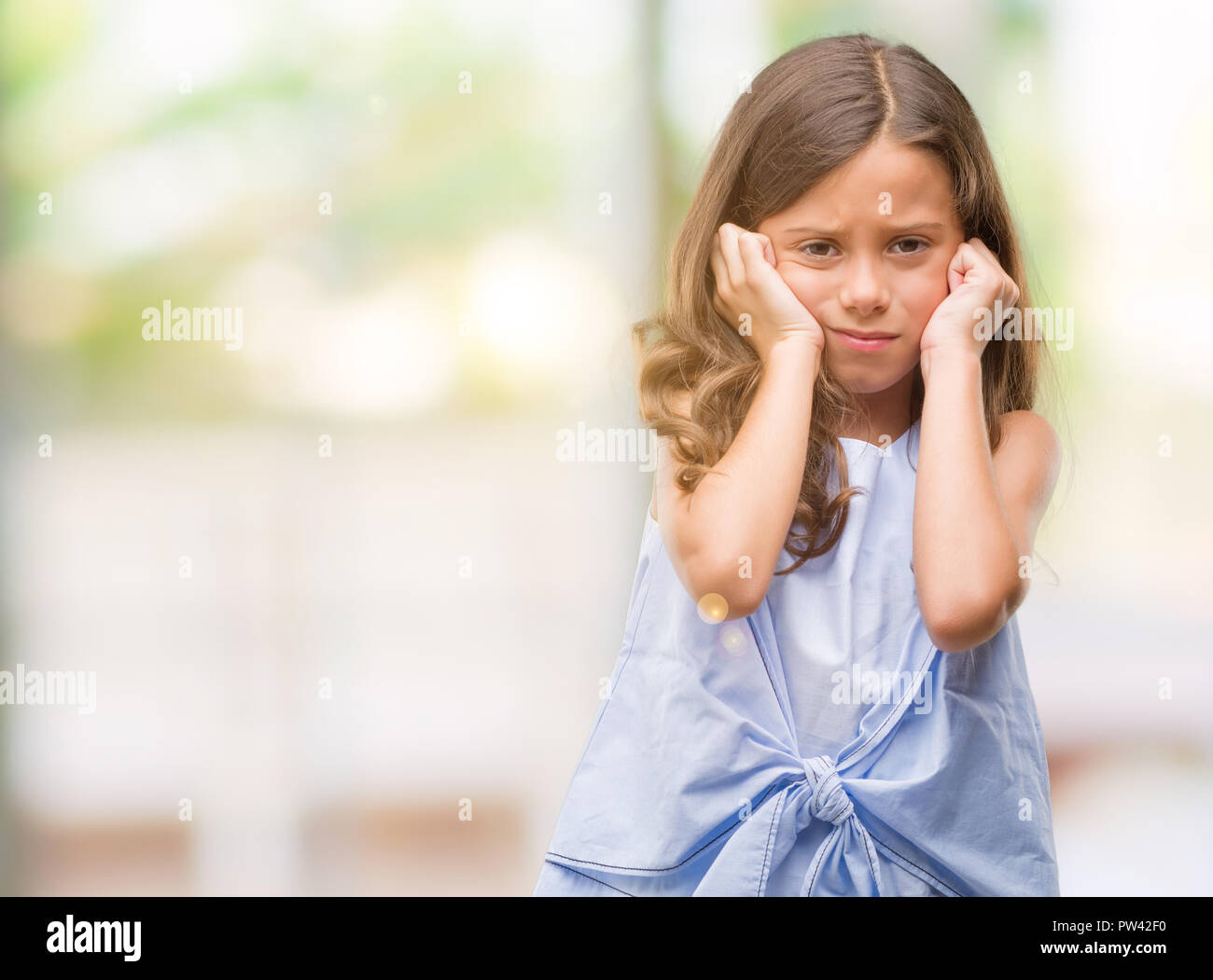 Brunette hispanic girl covering ears with fingers with annoyed ...