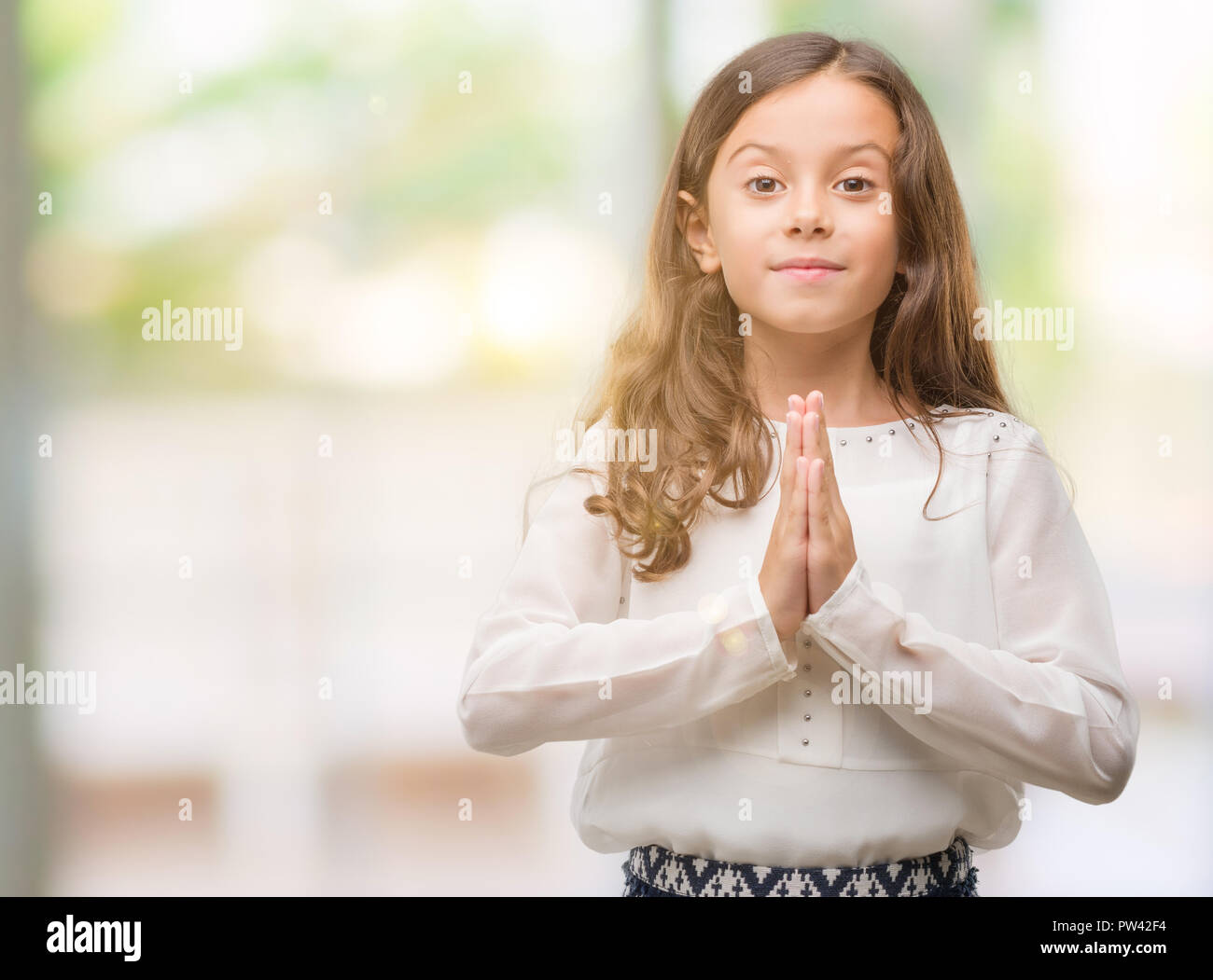 Brunette hispanic girl praying with hands together asking for ...