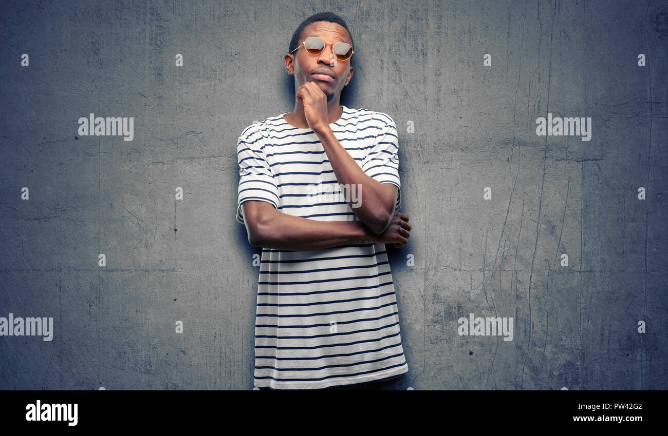 African black man wearing sunglasses thinking and looking up expressing ...