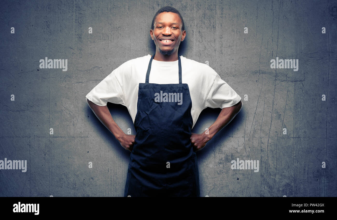 African man shop owner wearing apron confident and happy with a big ...