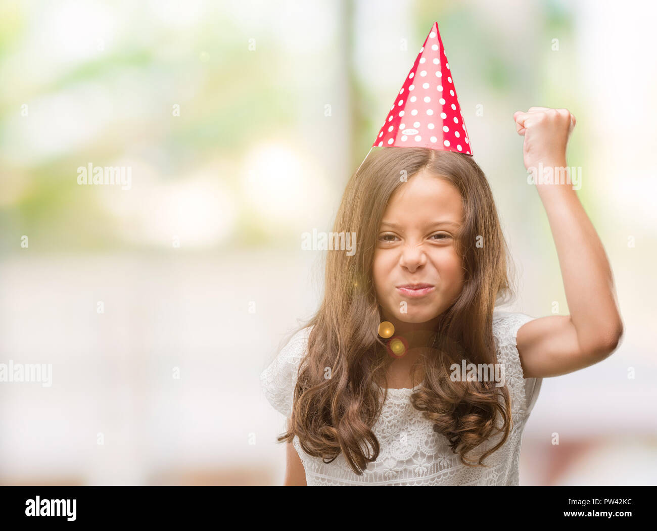 Brunette hispanic girl wearing birthday hat annoyed and frustrated ...